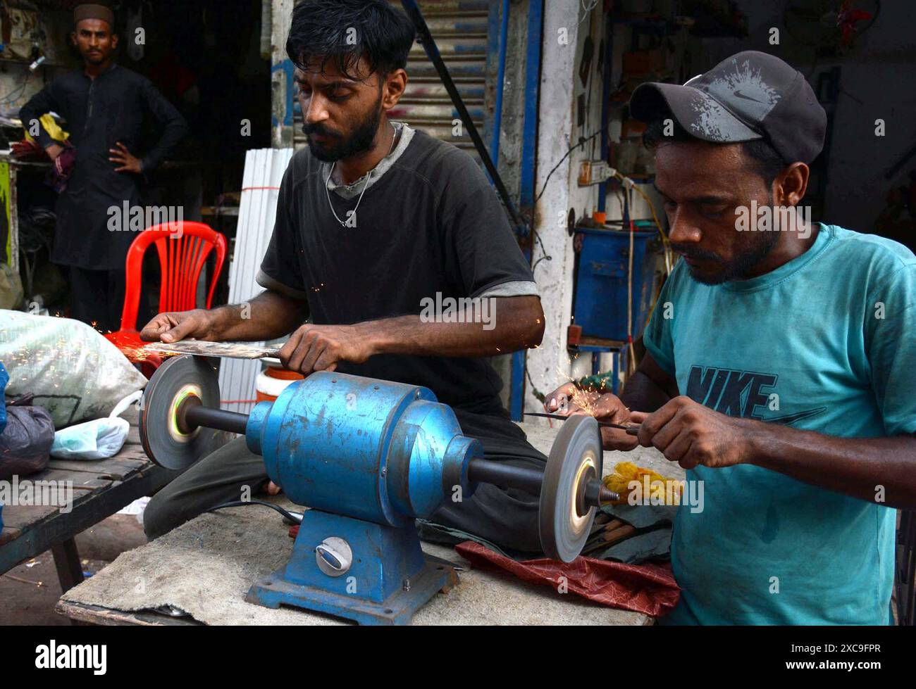 KARACHI, PAKISTAN, JUN 15: Blacksmiths are busy in sharpen and ...