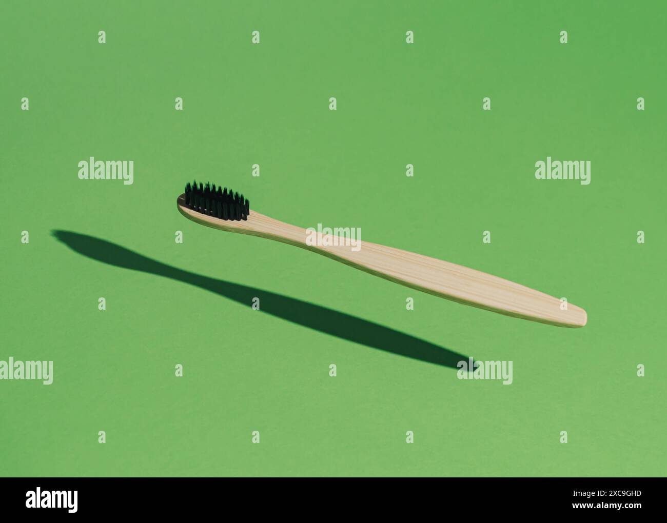 Organic bamboo toothbrush on green background with sun shadow. Minimal ...