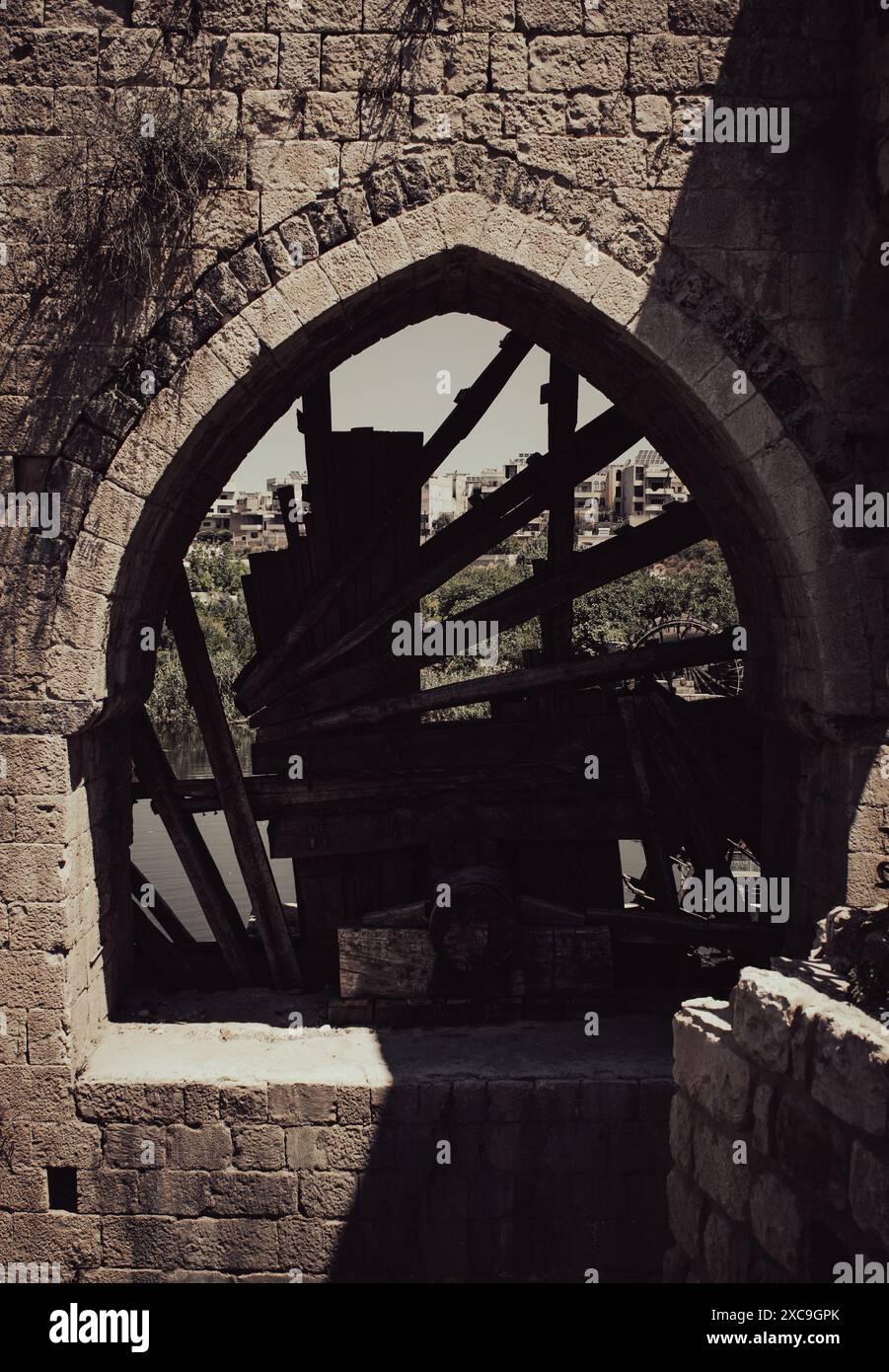 An ancient stone arch with a view of a wooden structure in Hama, Syria ...