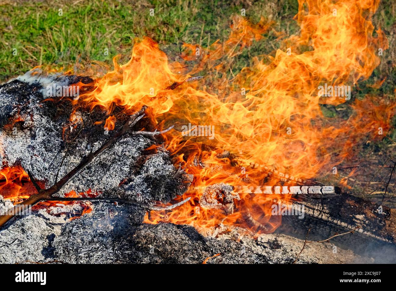The fire is burning in a pile of what appears to be garden waste Stock ...