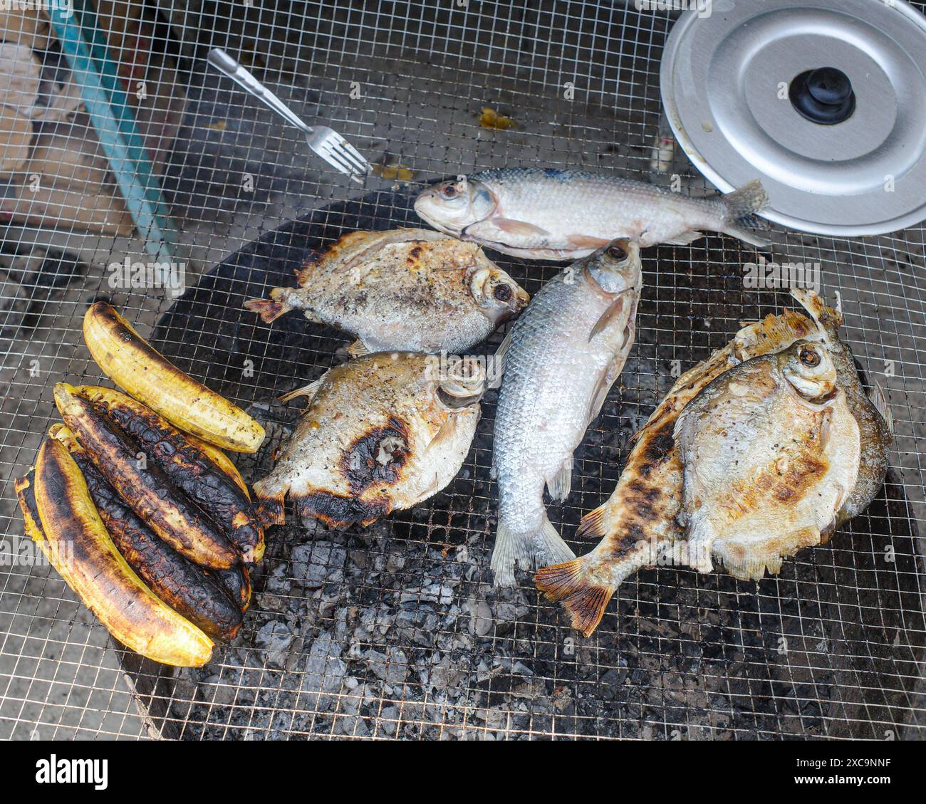 Lima, Peru - Dec 3, 2023: Fresh fish and plantains cooking on a grill ...