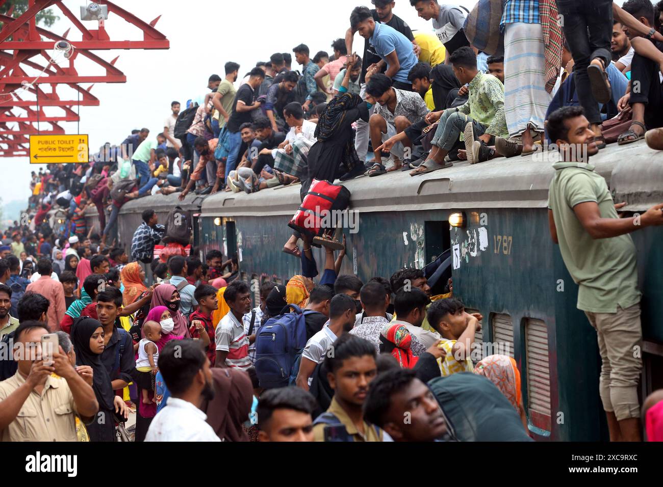 People are boarding a train at the Tongi railway station in Tongi on ...