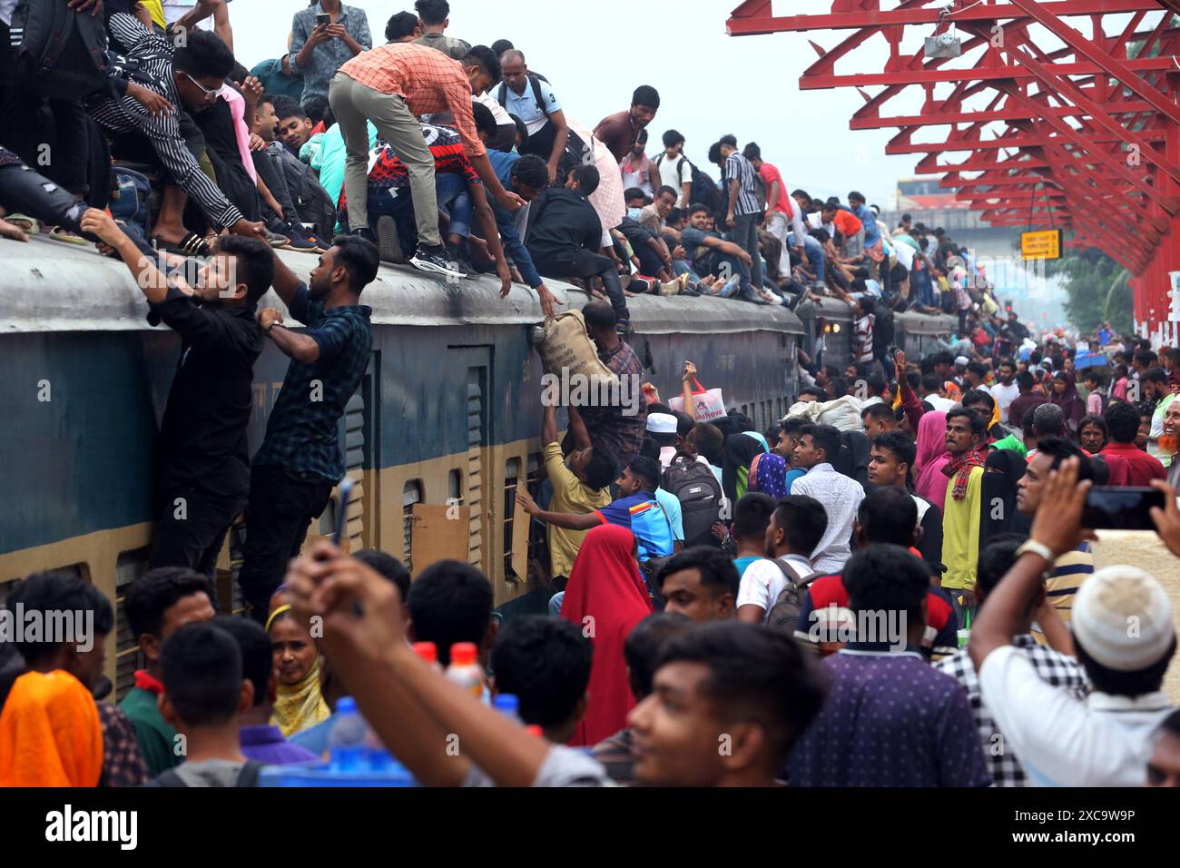 People are boarding a train at the Tongi railway station in Tongi on ...