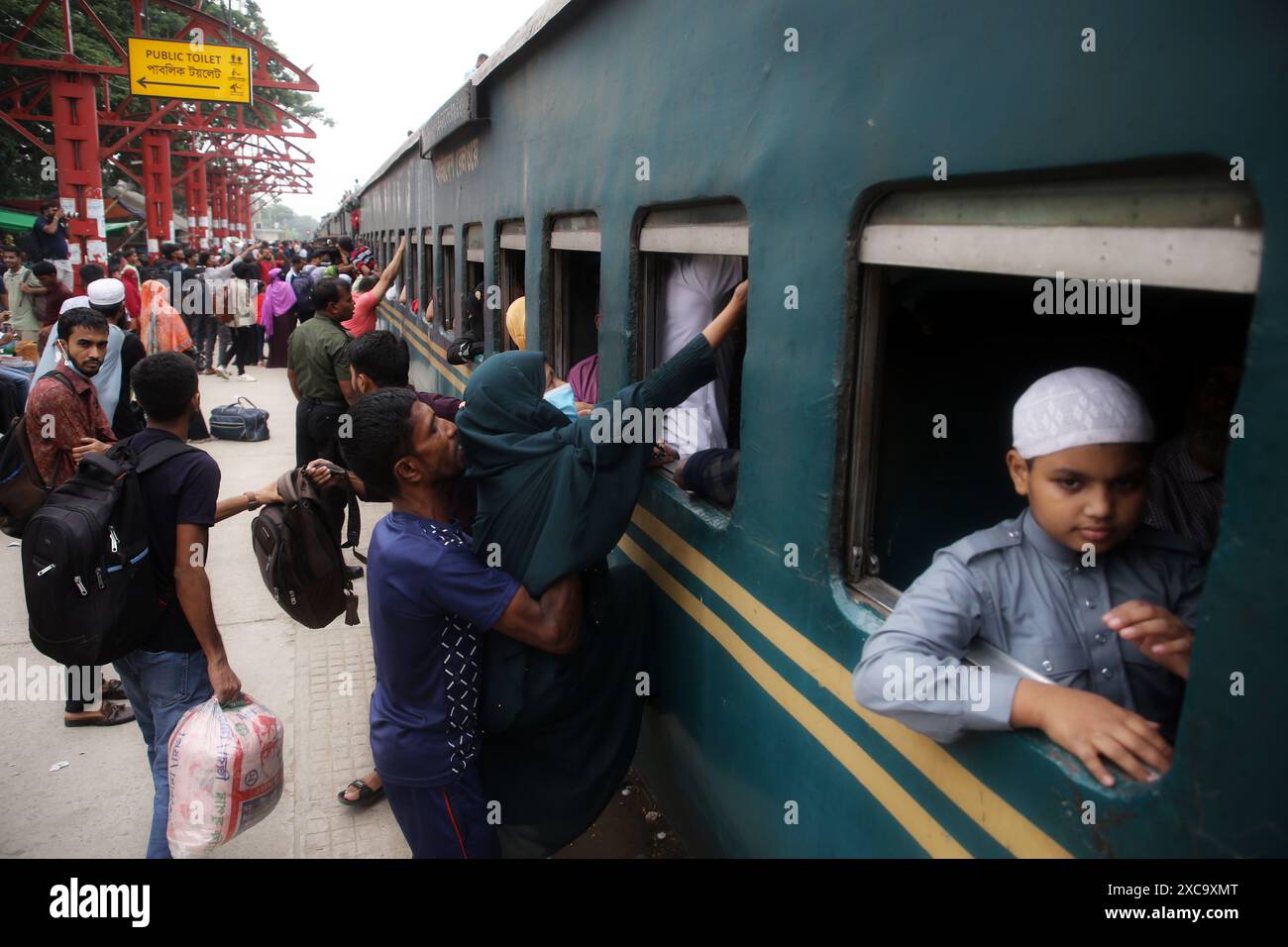 People are boarding a train at the Tongi railway station in Tongi on ...