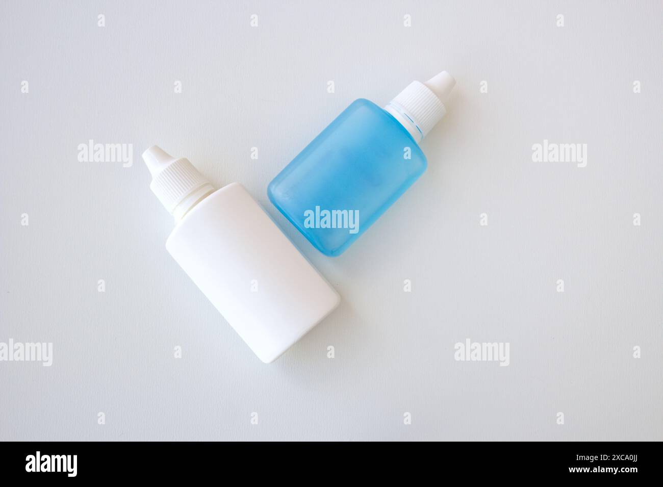 Two medical squeezable plastic dropper bottles on white background with ...