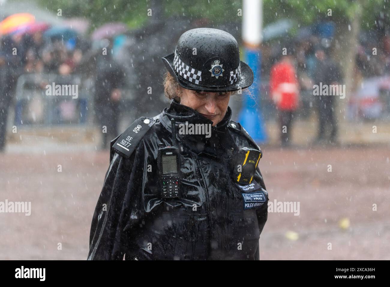 Female Special Constable getting very wet during a rainstorm during ...