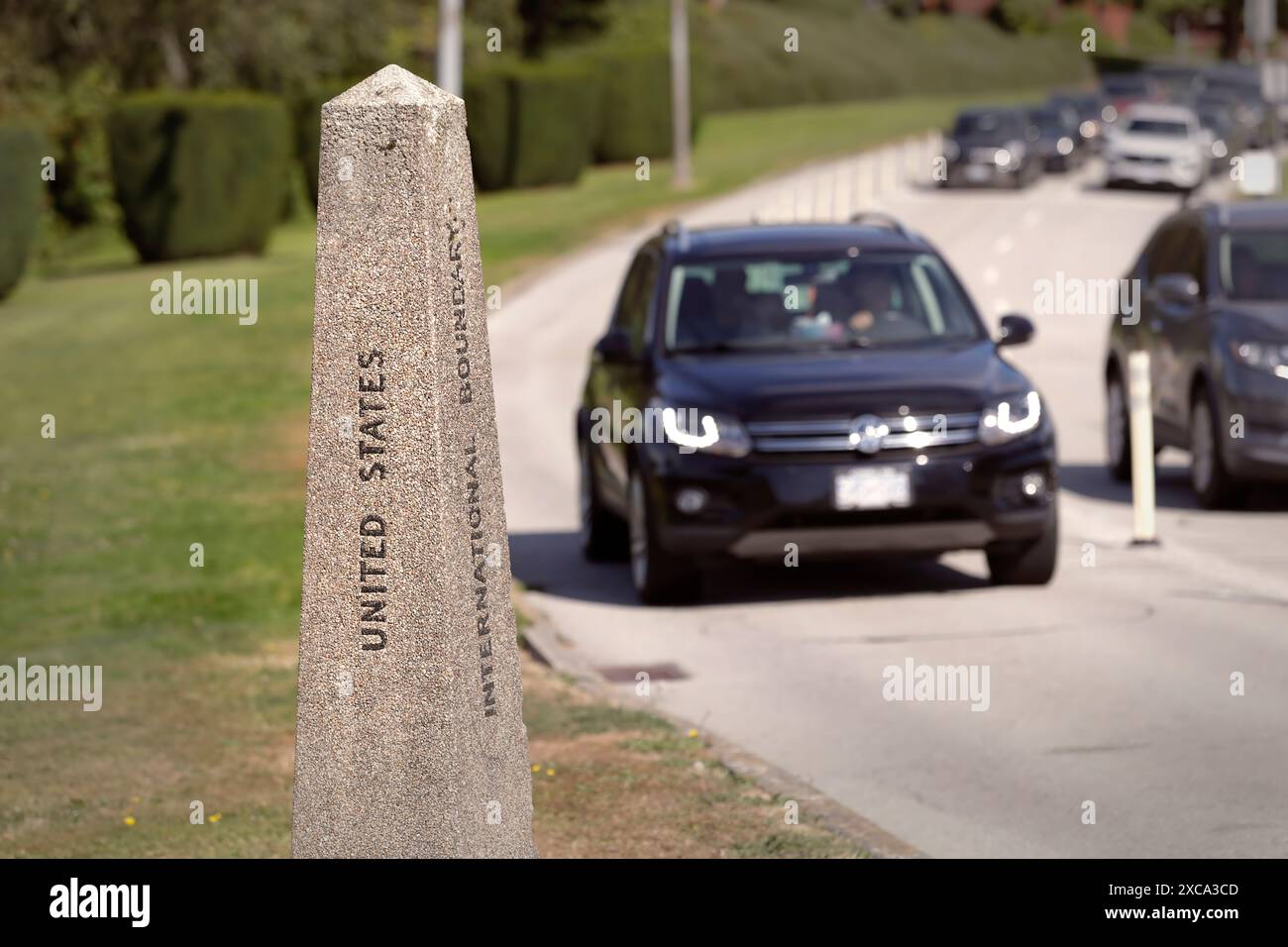 Vehicles approach a border demarcation monument as they arrive from ...