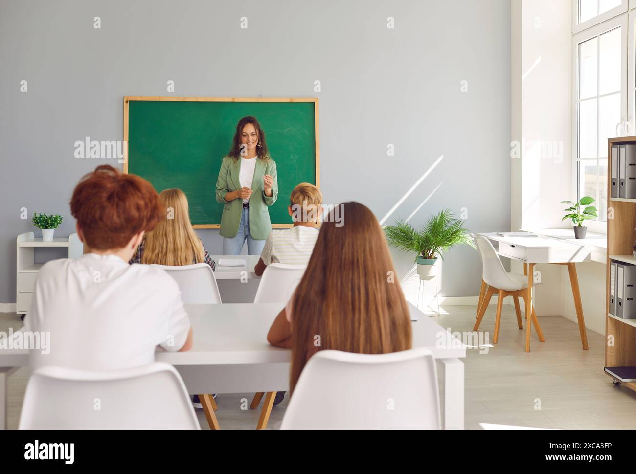Woman teacher standing in the classroom in junior high school with ...