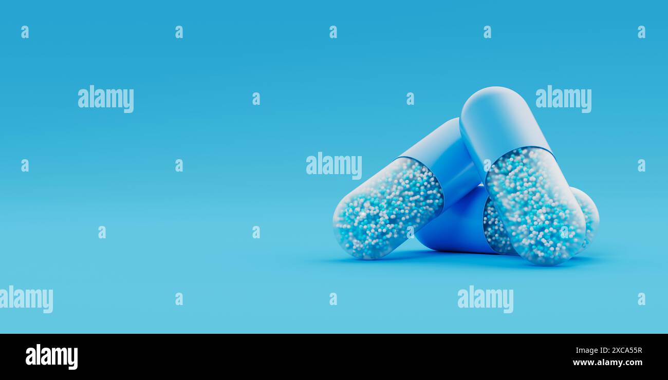 Three blue transparent capsules, pills with blue granules inside lay on ...