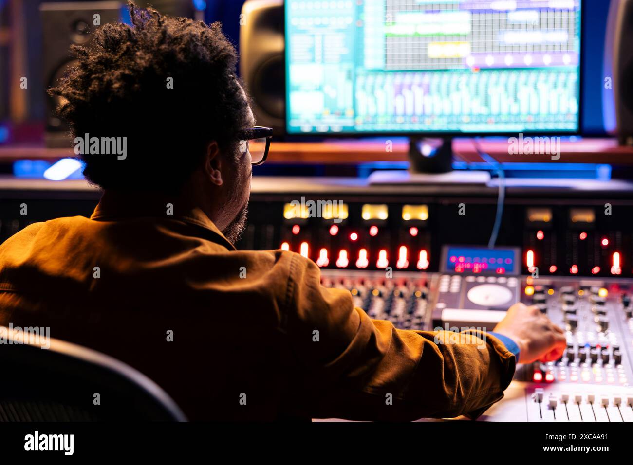 Sound engineer uses mixing console and handling panel board buttons ...