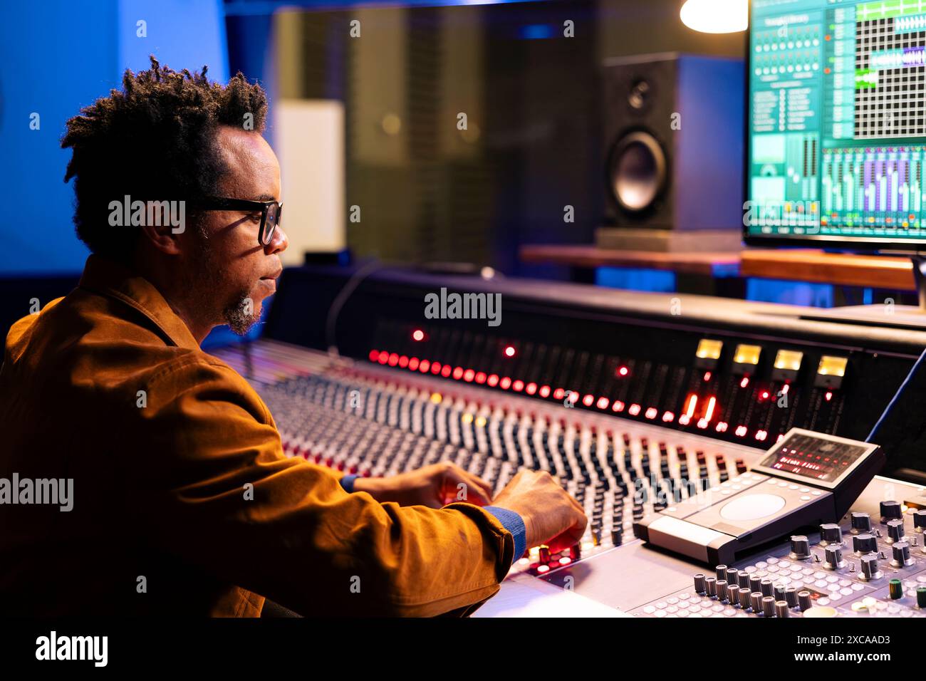 African american sound technician using audio console with moving ...