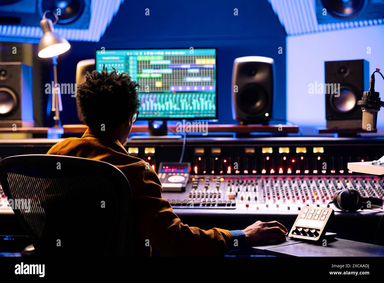 Music producer editing and processing sounds in control room with audio ...
