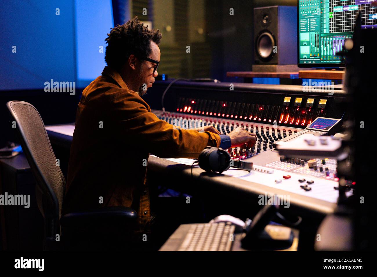 African american tracking engineer editing tunes in control room ...
