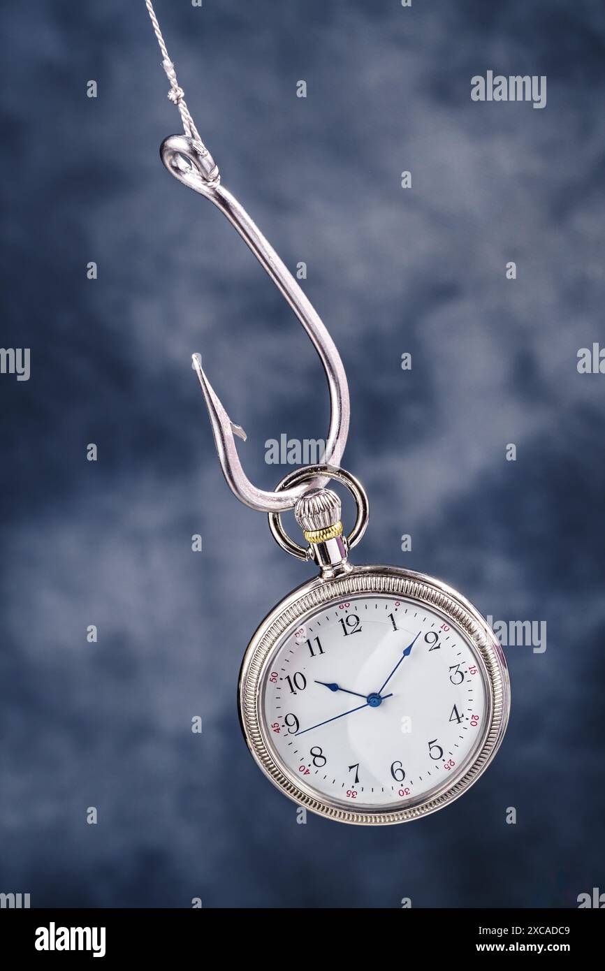 Pocket watch hanging on a fish hook. Time trap concept, idea of time ...