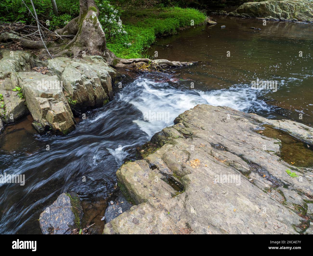 From a bird's-eye view, a silky-smooth waterfall elegantly winds ...