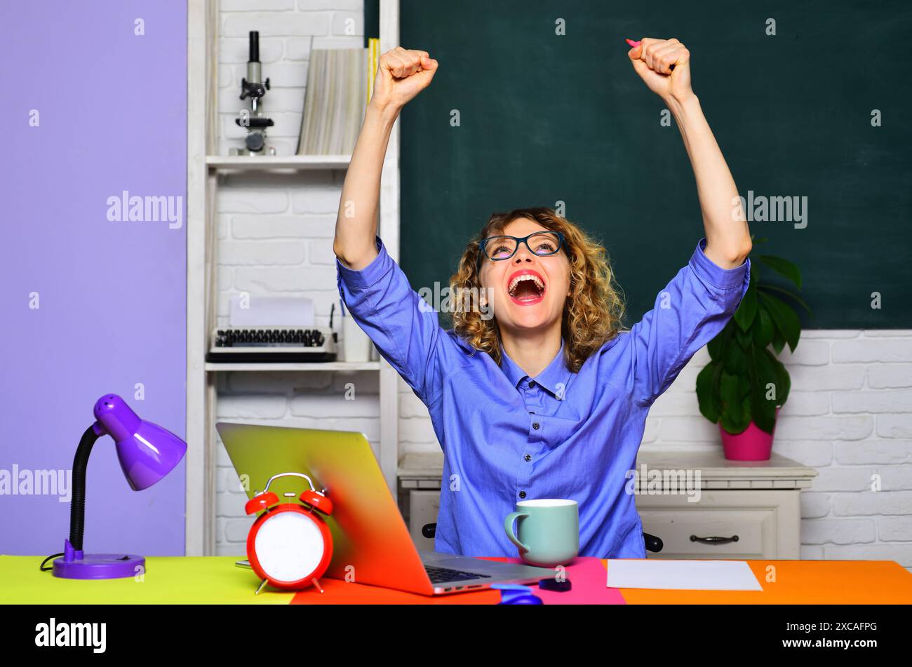 Beautiful female professor in glasses working with laptop computer. E ...