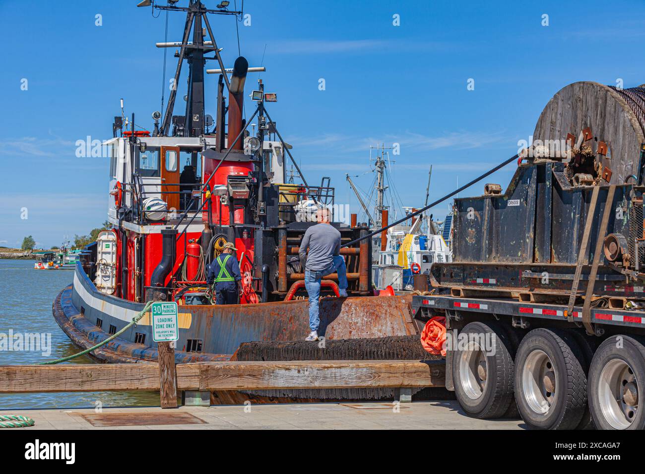 Coastal tugboat winding a new towing cable in Steveston Harbour British ...