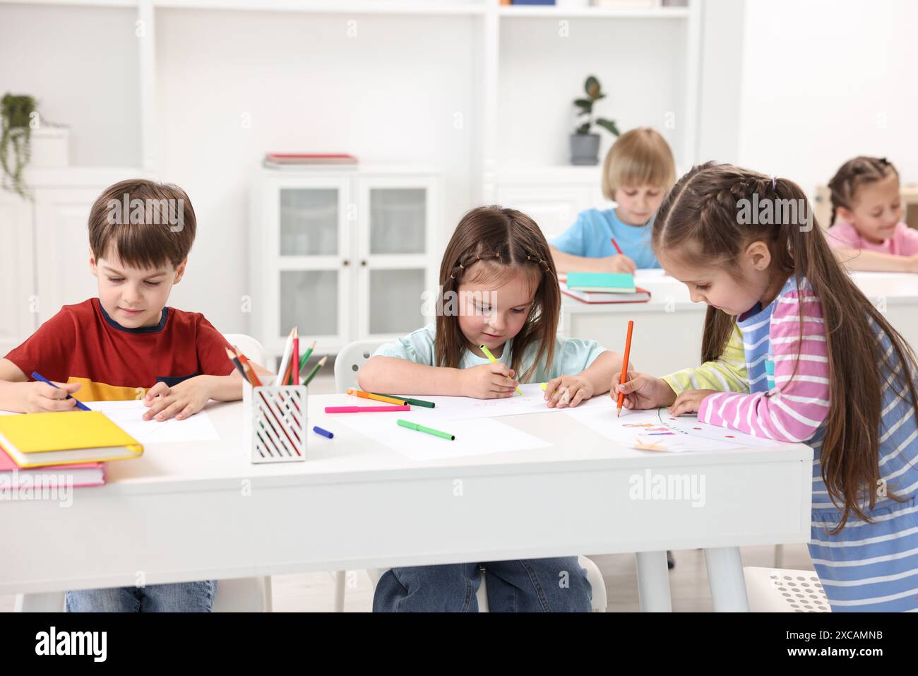 Group of children drawing at table indoors Stock Photo - Alamy