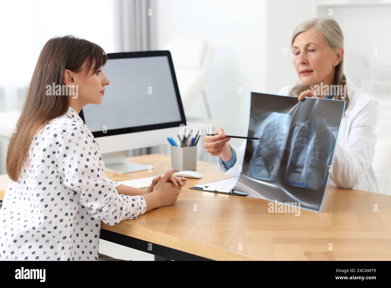 Lung disease. Doctor showing chest x-ray to her patient in clinic Stock ...