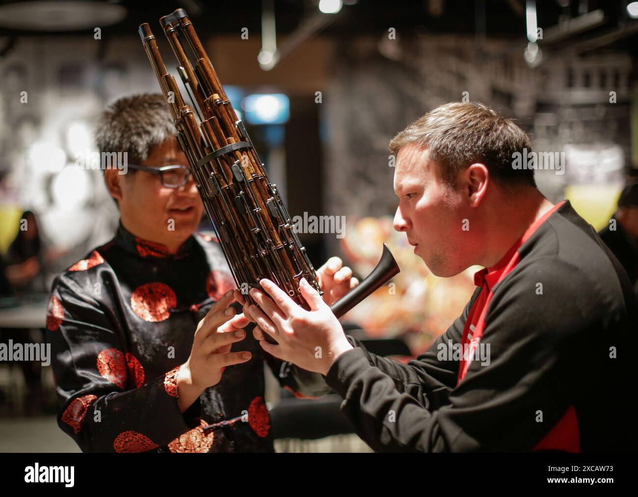 Vancouver, Canada. 15th June, 2024. A man (R) tries traditional Chinese ...
