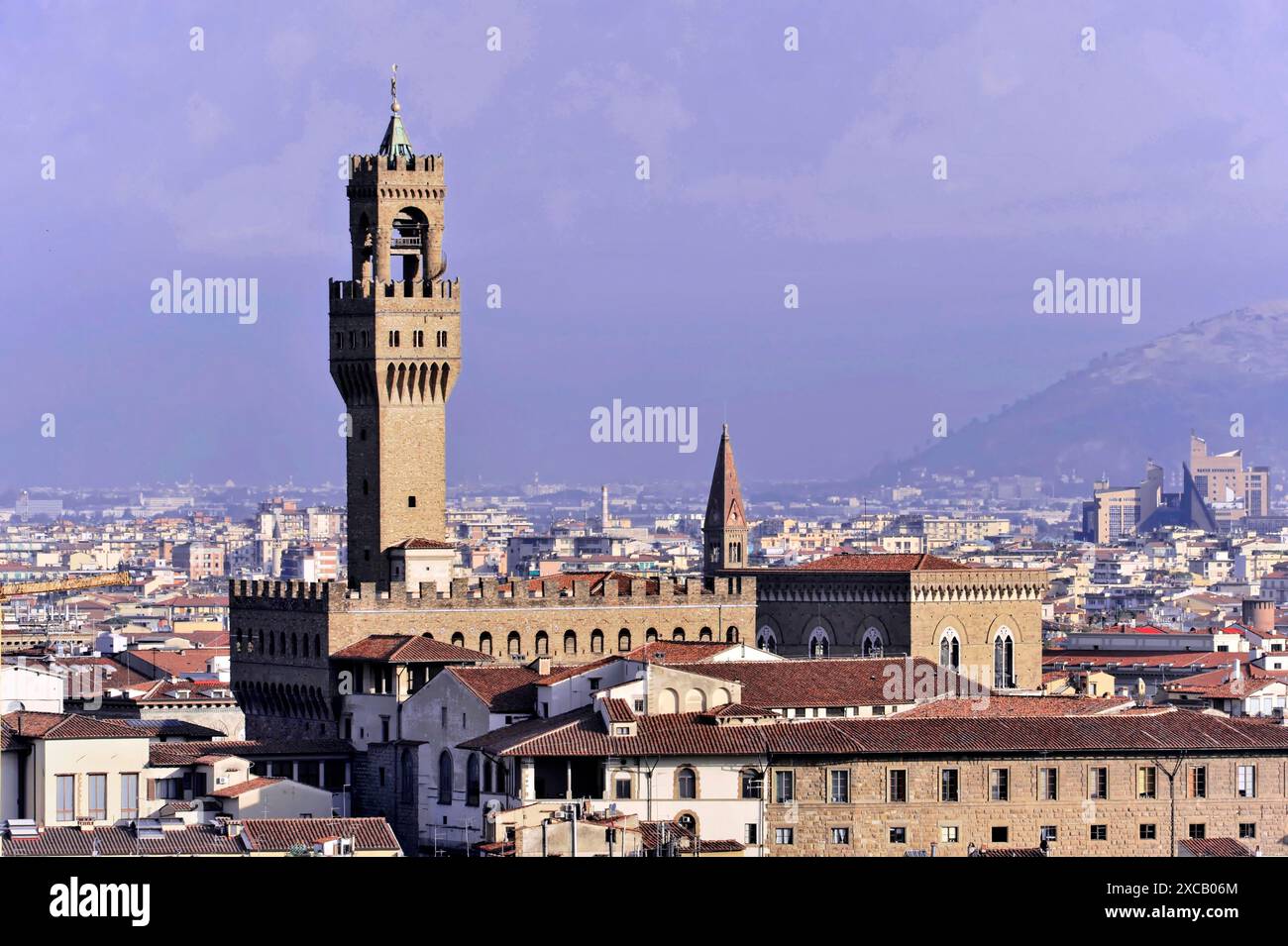 Tall historic tower rising above the city with hills and a blue sky in ...