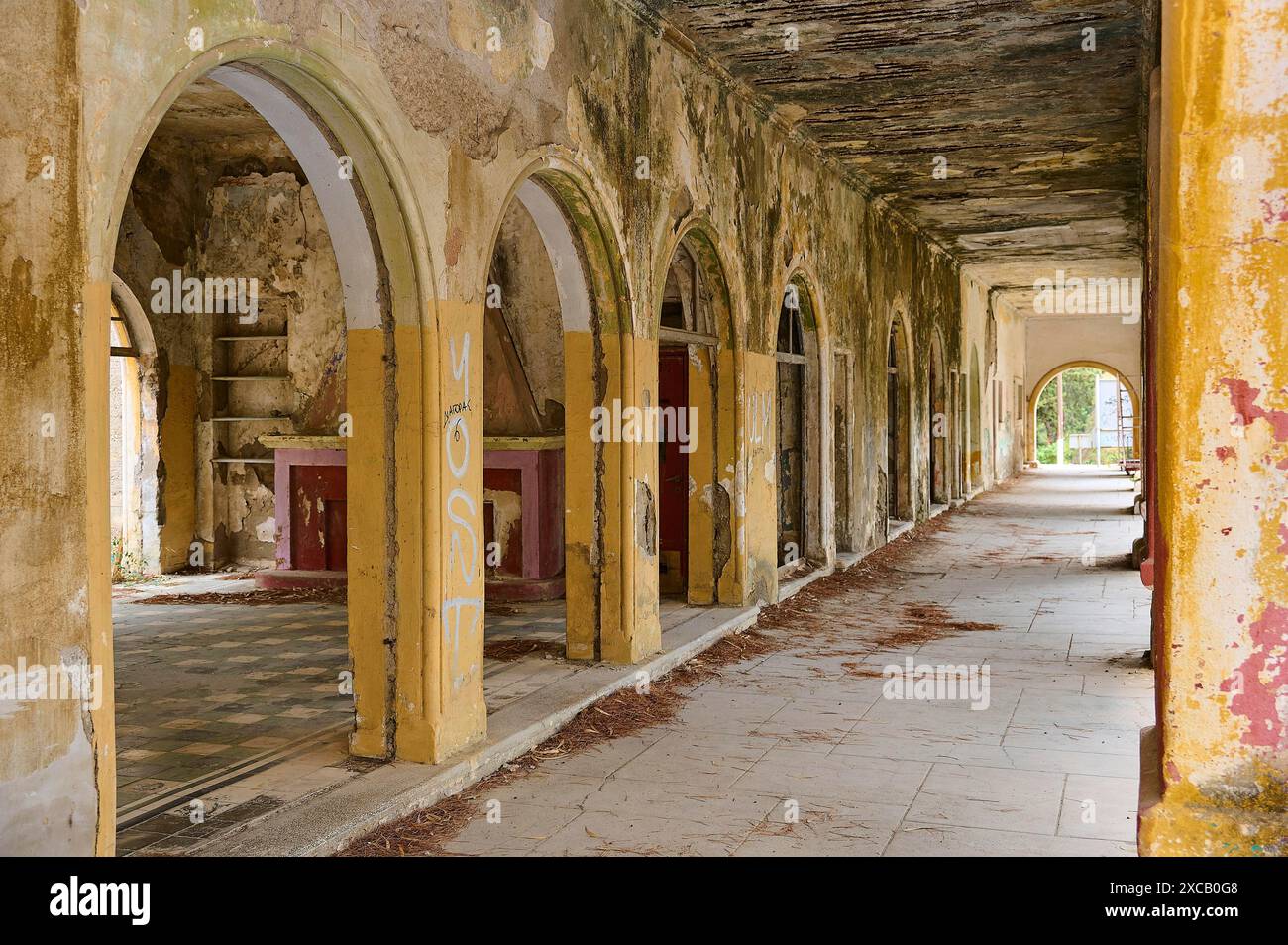 A dilapidated hall with arches and dirty walls, showing signs of ...