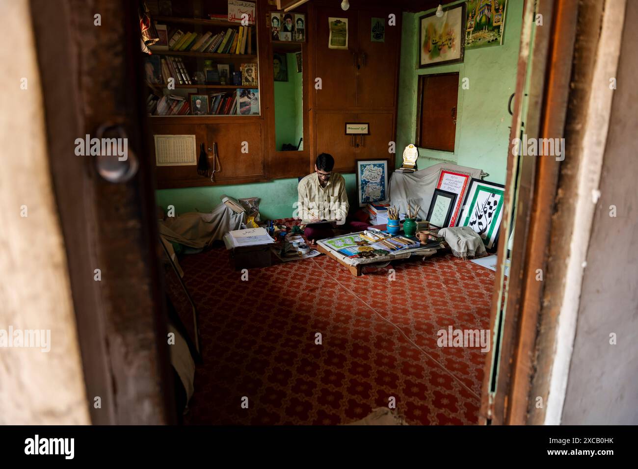 A calligrapher is seen working at his workplace. Calligraphy is the art ...