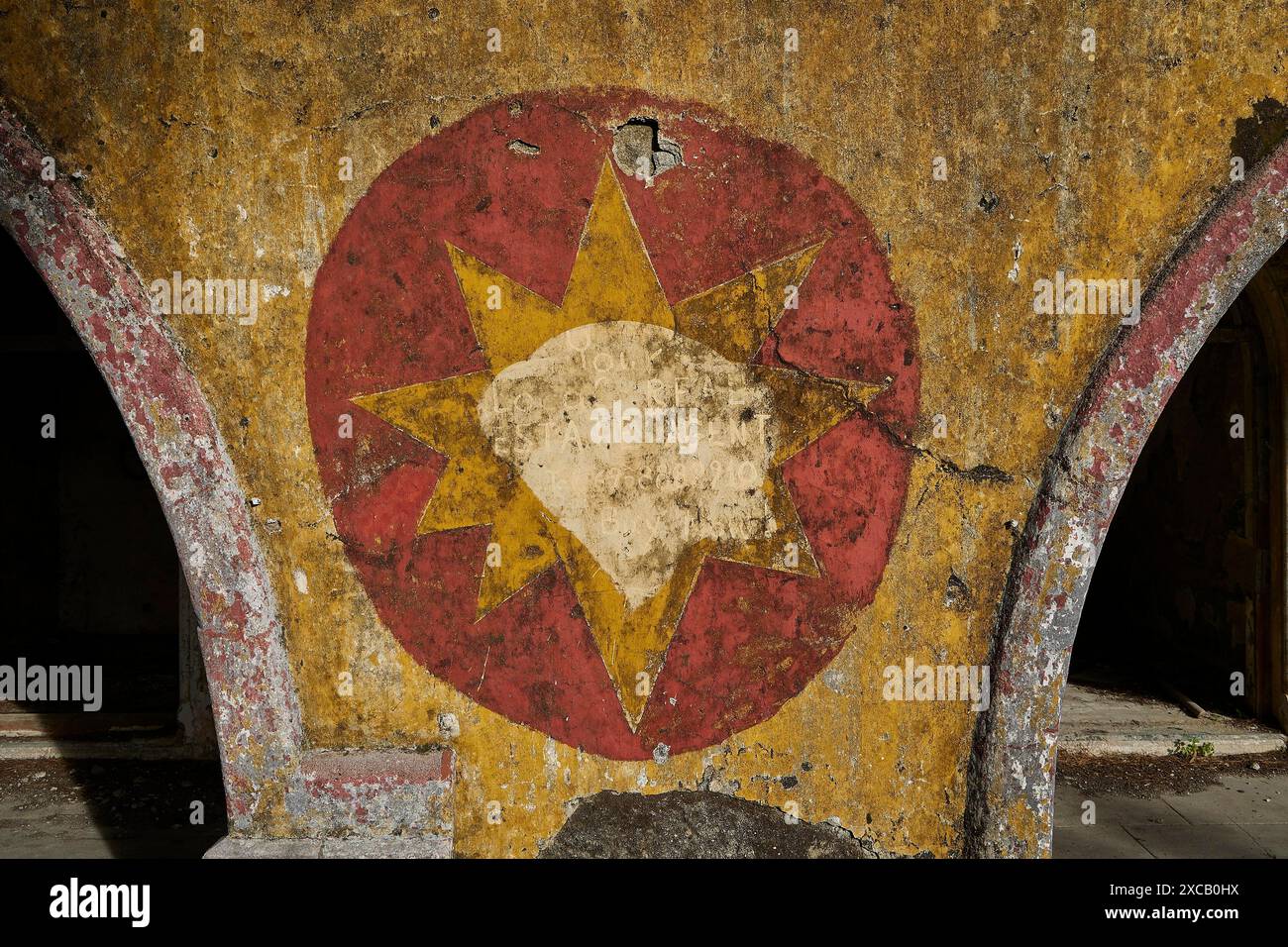 A ruined wall with a faded red and yellow star symbol on it, Italian ...