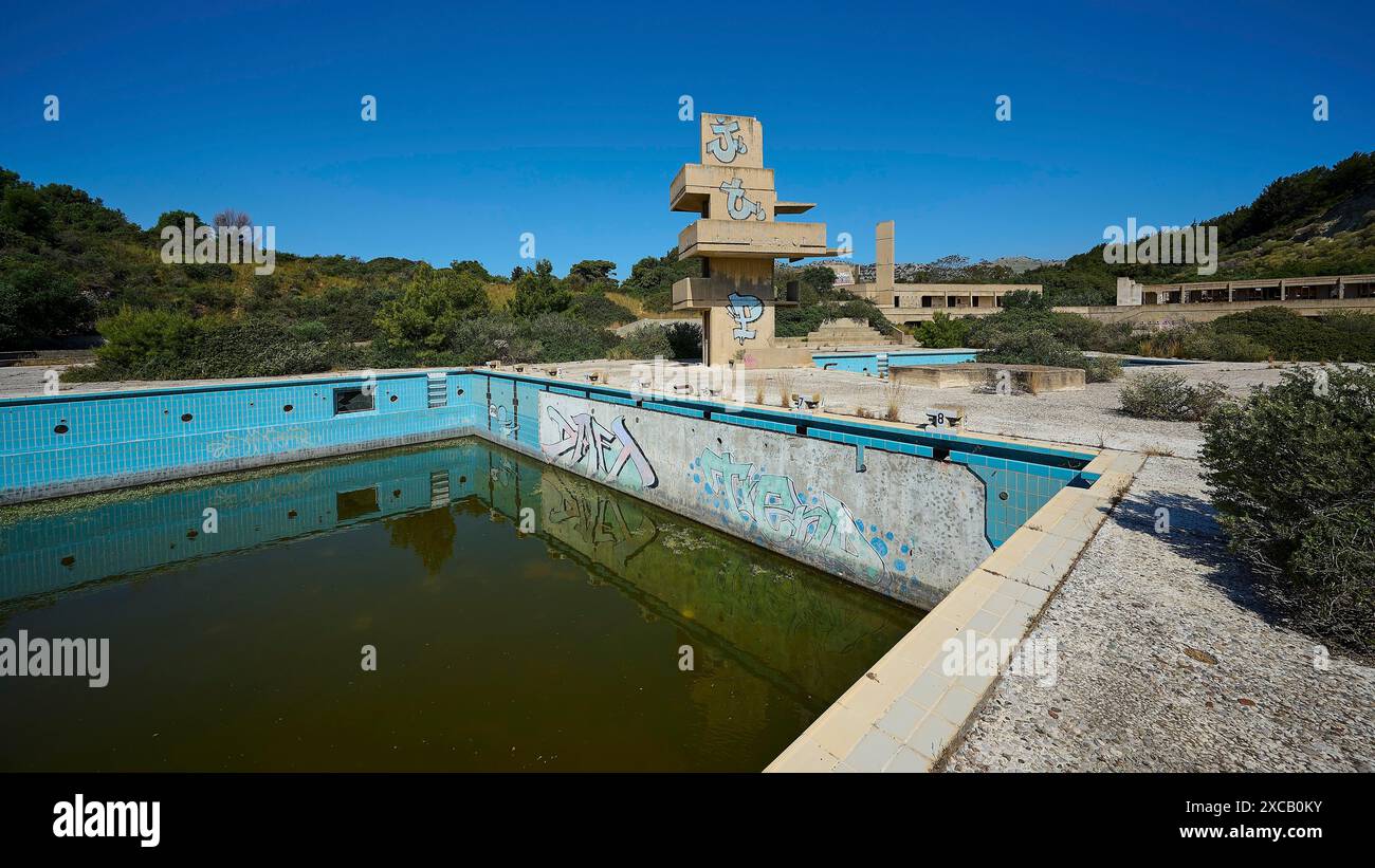 Abandoned swimming pool with graffiti, green water, and surrounding ...