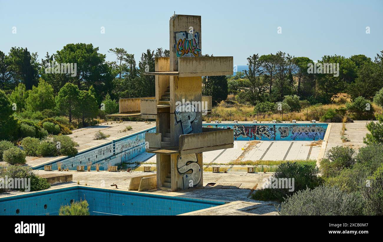 Dilapidated swimming pool with graffiti and concrete platform ...