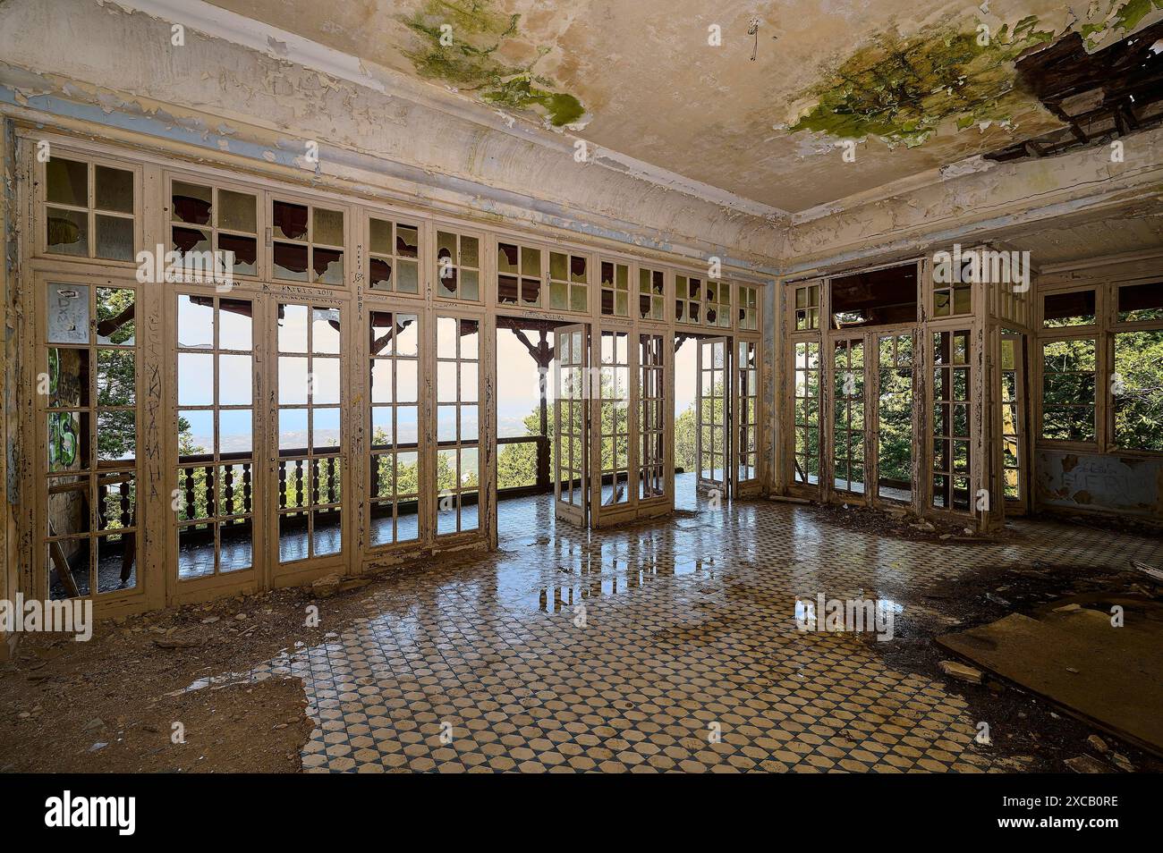 Abandoned room with broken windows, dilapidated floor and view of the ...