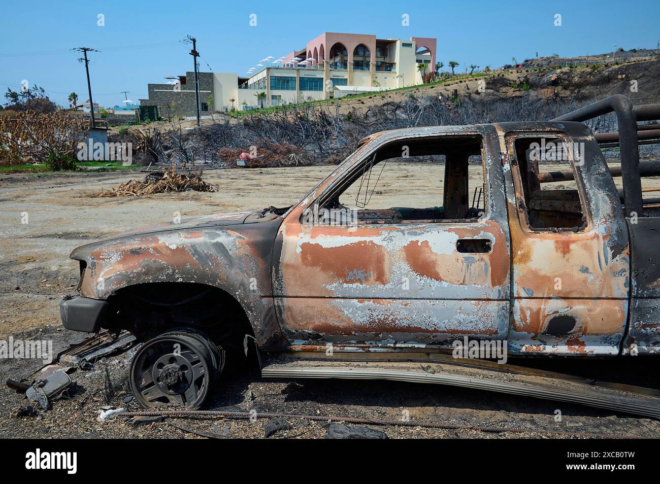 Completely burnt out lorry in a destroyed landscape with a building and ...