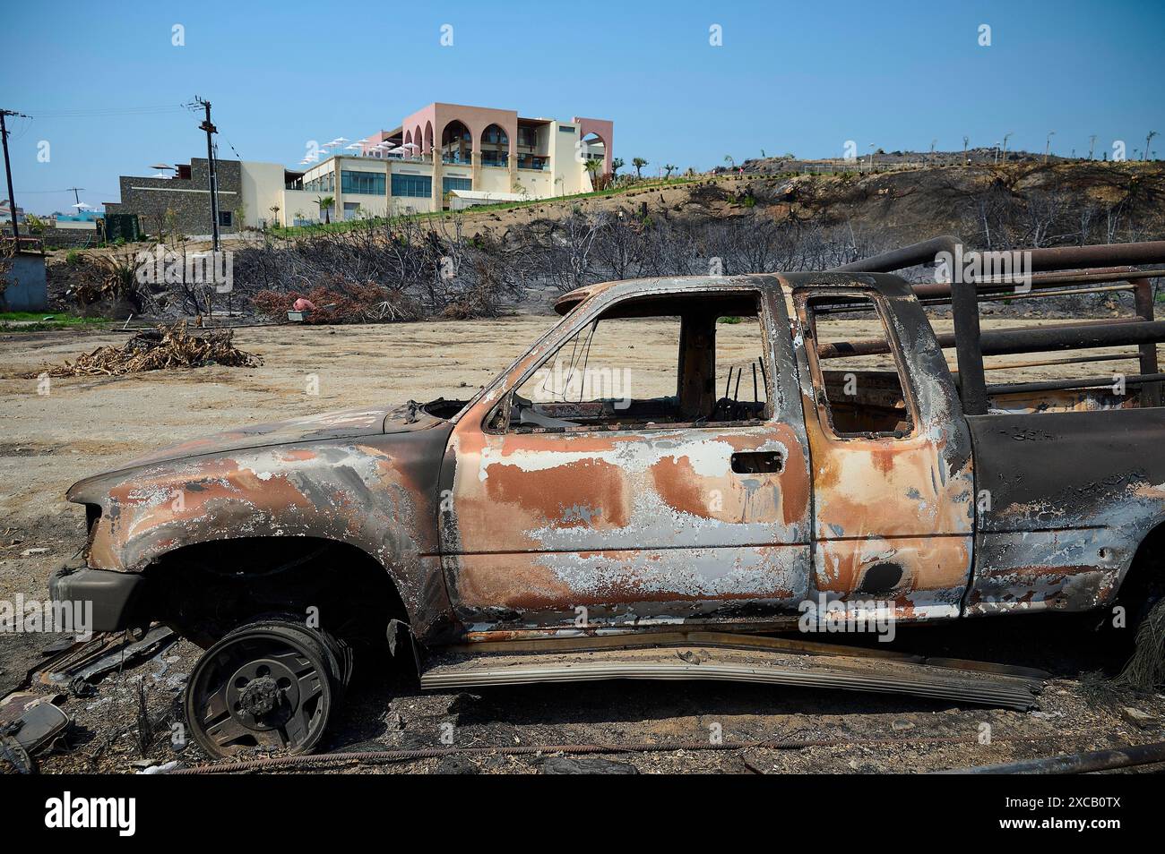 Destroyed lorry in a devastated landscape with burning trees and a ...
