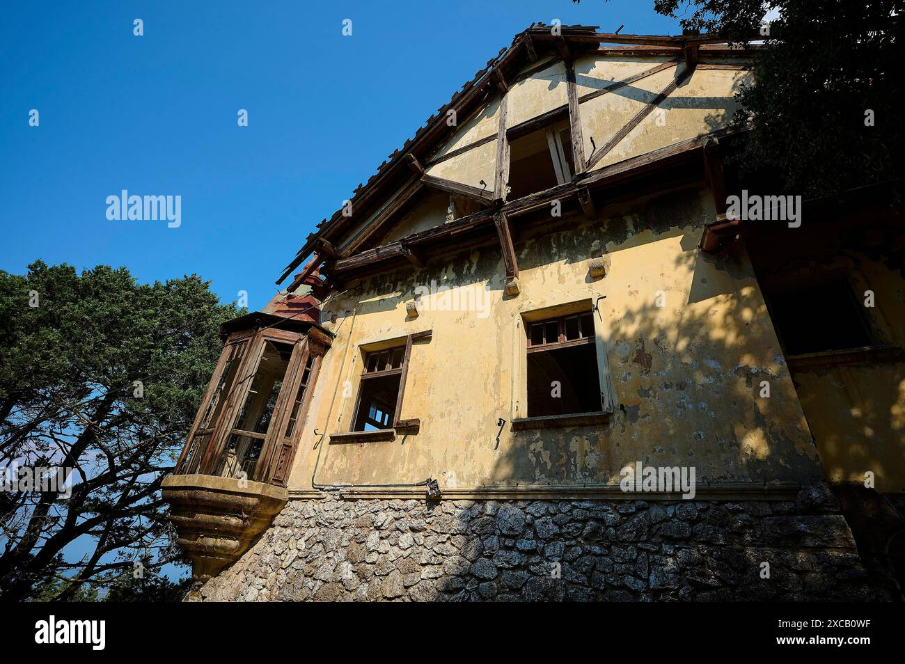 An old, dilapidated building with yellow walls and a weathered exterior ...
