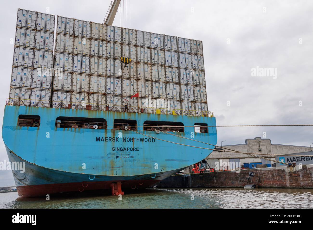 Large cargo ship, loaded with containers, in the harbour, blue hull and ...