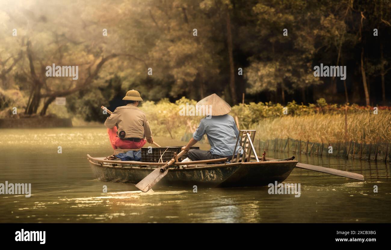 Tam Coc village boat tour in Vietnam. Man and a women rowing the Tam ...