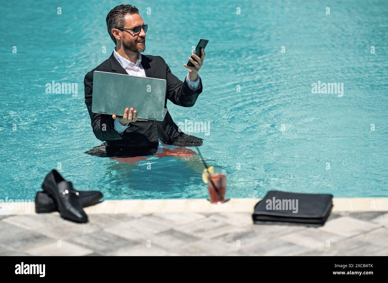Businessman in suit with laptop in swimming pool. Crazy business man ...