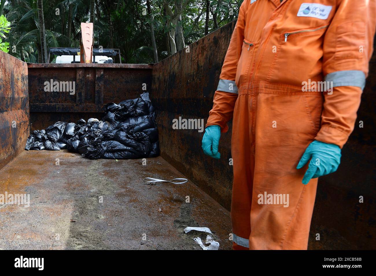 A worker waits to load bags of oil stained sands at Sentosa's Tanjong ...