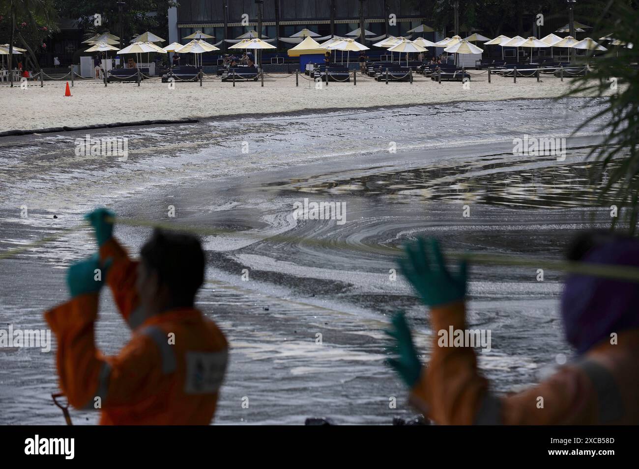 Workers prepare to clean oil spill as visitors hang out at Sentosa's ...