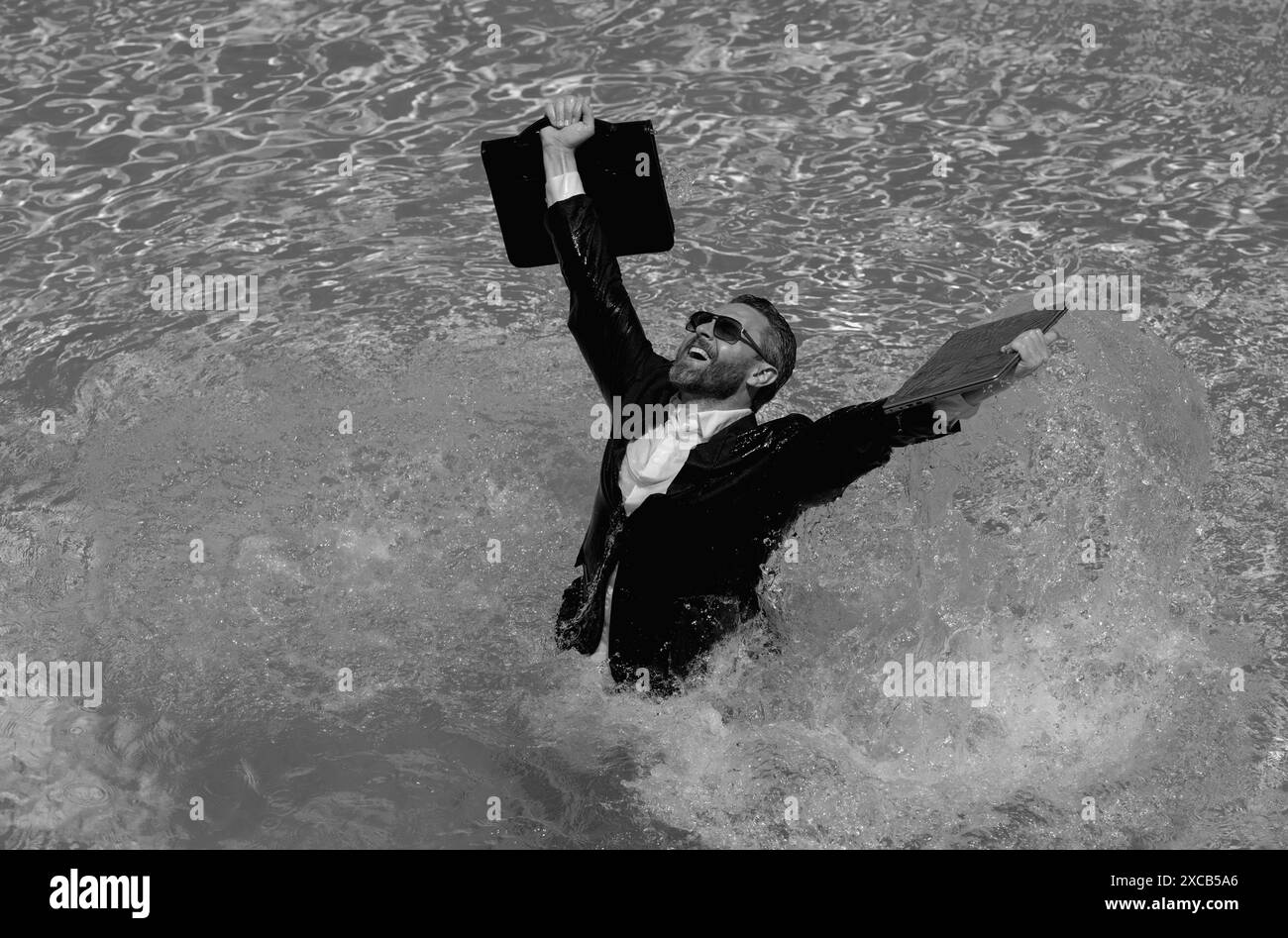 Funny excited businessman in suit with laptop in swimming pool. Crazy ...