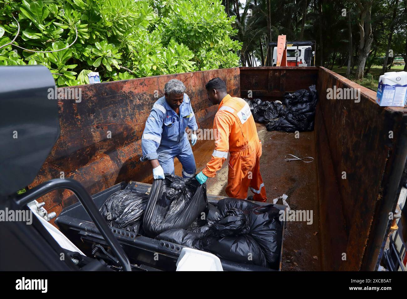 Workers load bags of oil stained sands at Sentosa's Tanjong Beach area ...
