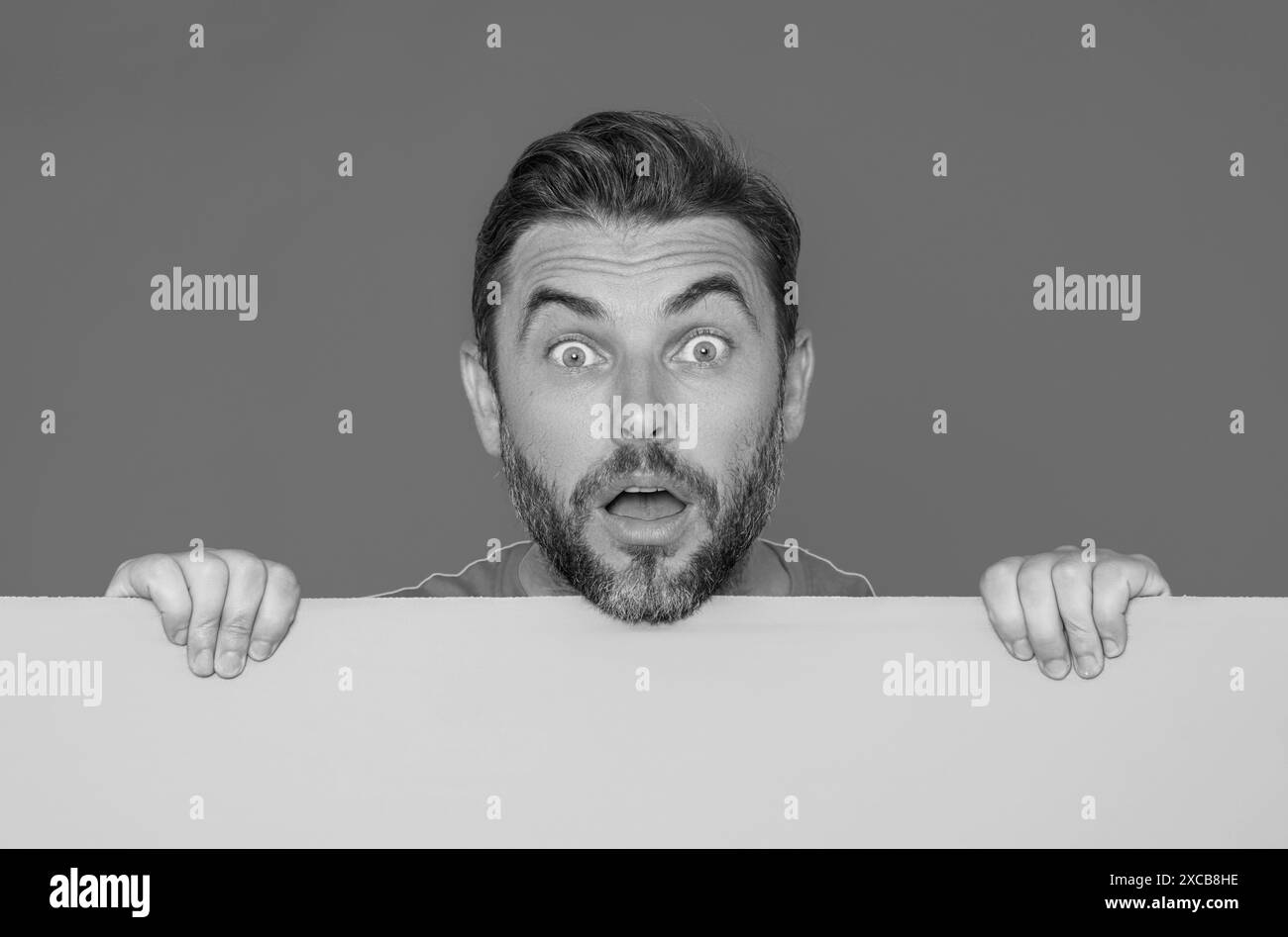 Surprised funny man holds the white sign, blank card. Placard ready for ...