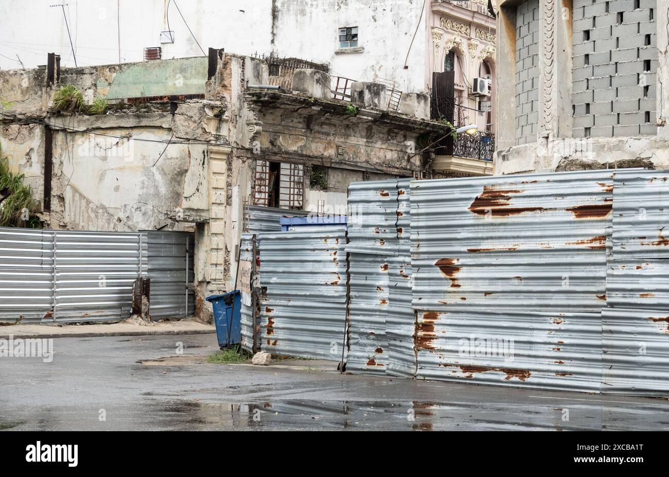 Corrugated galvanised iron fence, neglected old buildings in Havana ...