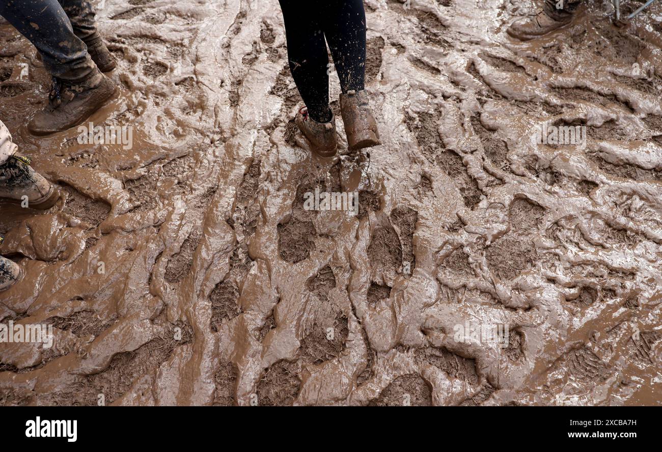 Leicestershire, UK. Saturday June 15, 2024. Festival goers wade through ...