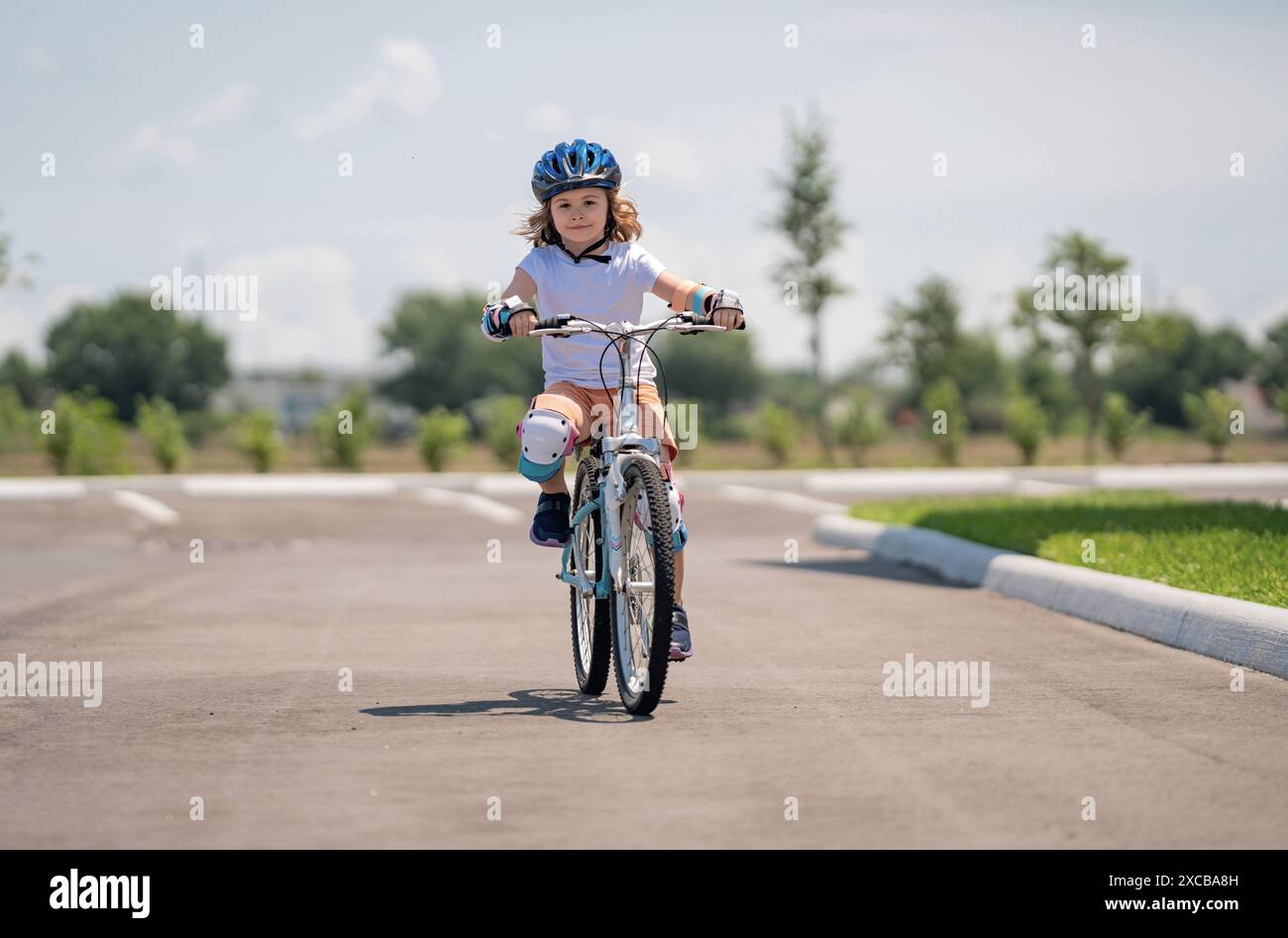 Kid riding on sporty bicycle in summer park. Child in safety helmet ...