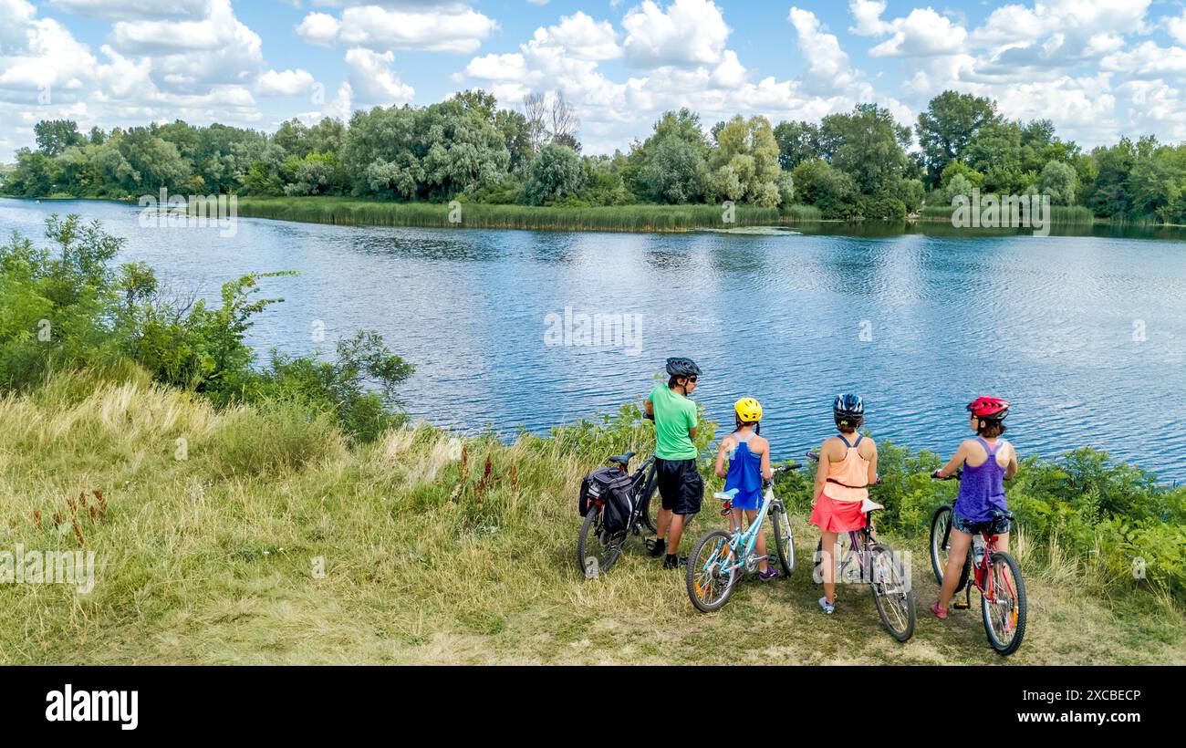 Family on bikes cycling outdoors, active parents and kids on bicycles ...