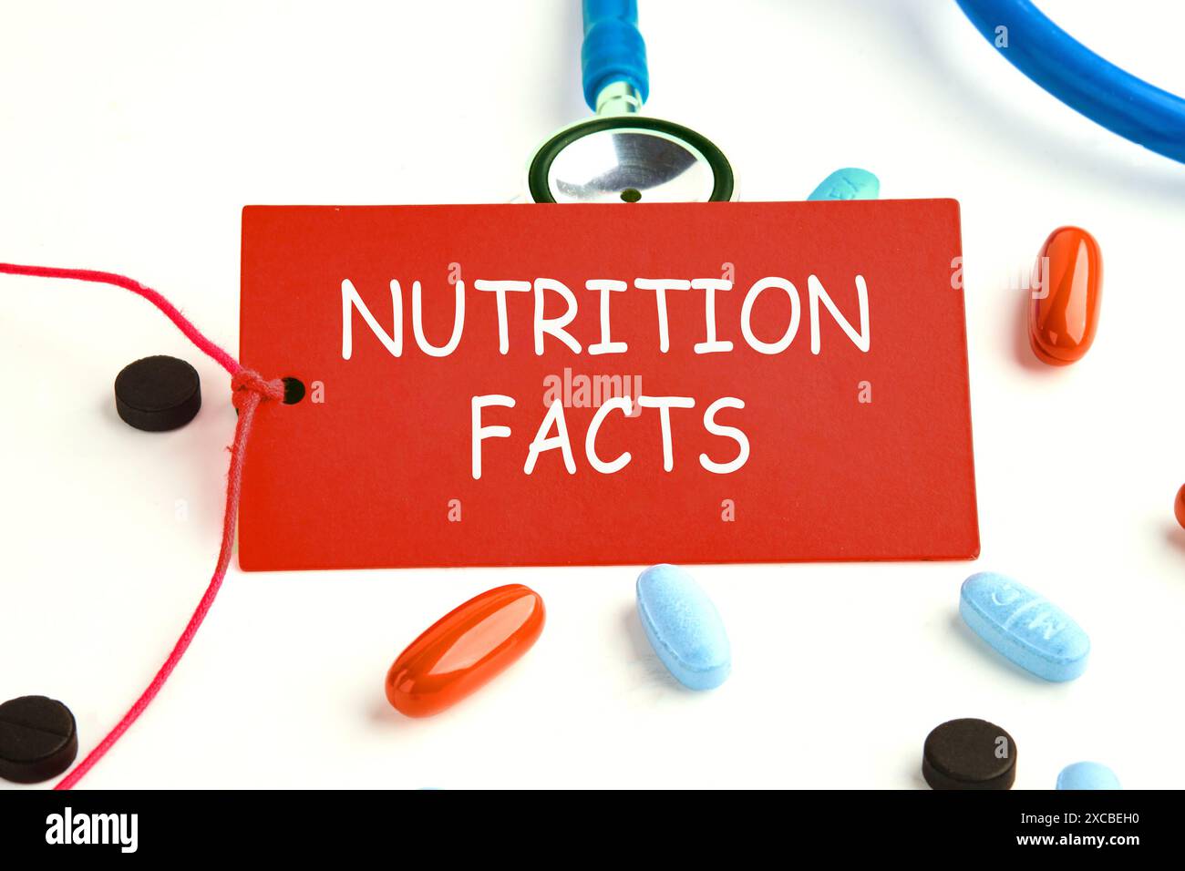 Nutrition facts text written on a red card on a stethoscope with pills ...