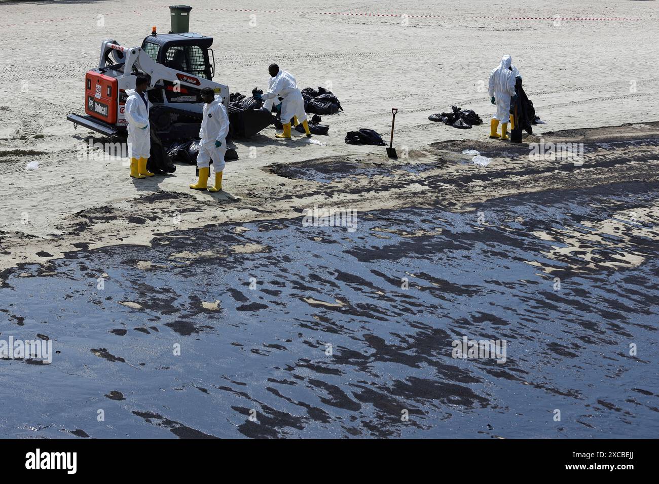 Workers clean oil spill along Sentosa's Tanjong Beach area in Singapore ...