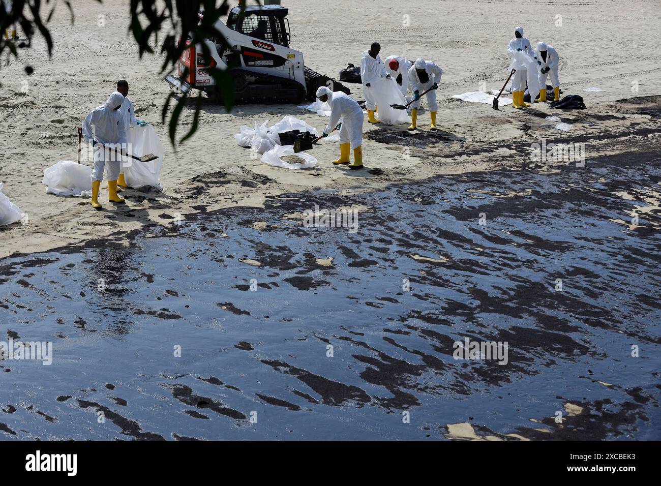 Workers clean oil spill along Sentosa's Tanjong Beach area in Singapore ...