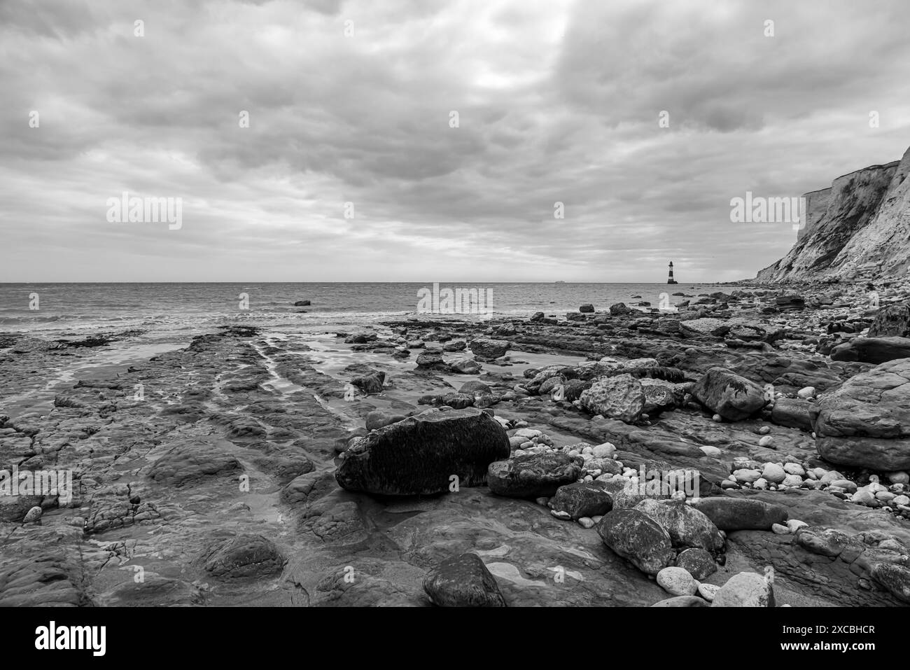 A black and white view of Beachy Head Lighthouse and the cliffs and ...